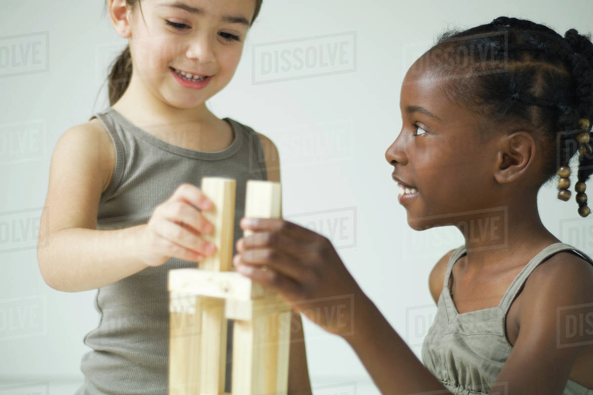 Two girls playing with building blocks together, both smiling - Royalty ...