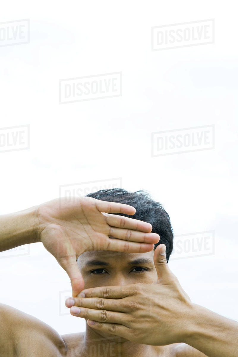 Man looking at camera through finger frame, close-up - Stock Photo ...