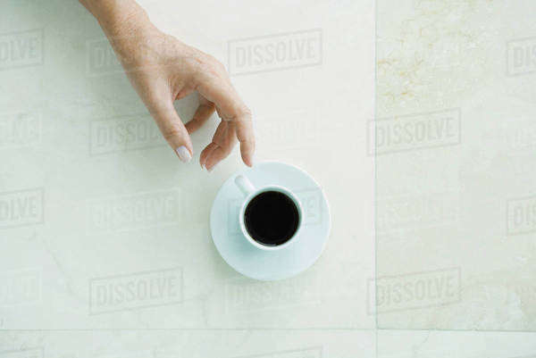 Hand reaching for coffee cup, viewed from directly above - Royalty-free ...