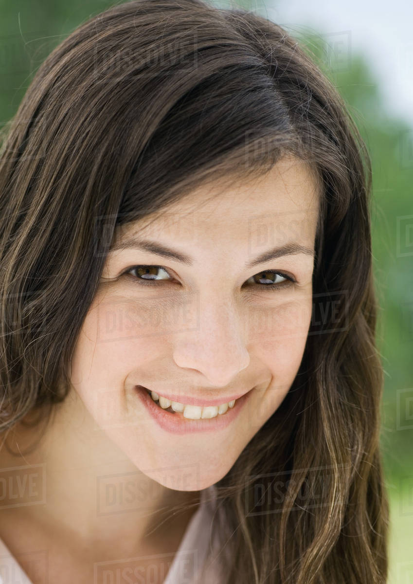 Young woman biting lip, portrait - Royalty-free Stock Photo | Dissolve
