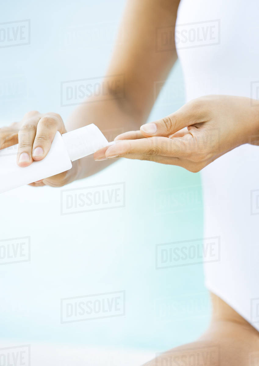 Woman applying sunscreen - Stock Photo - Dissolve