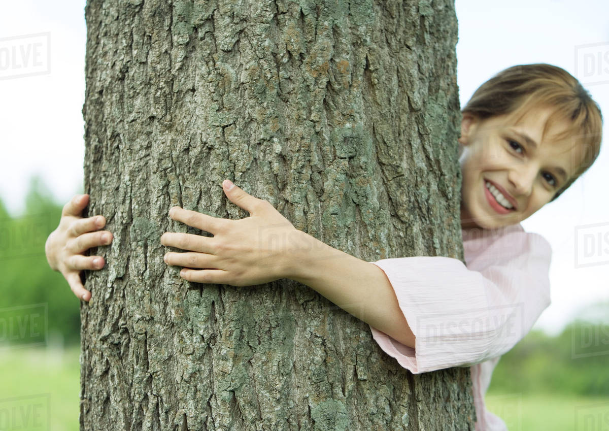 Girl hugging tree and smiling - Royalty-free Stock Photo | Dissolve