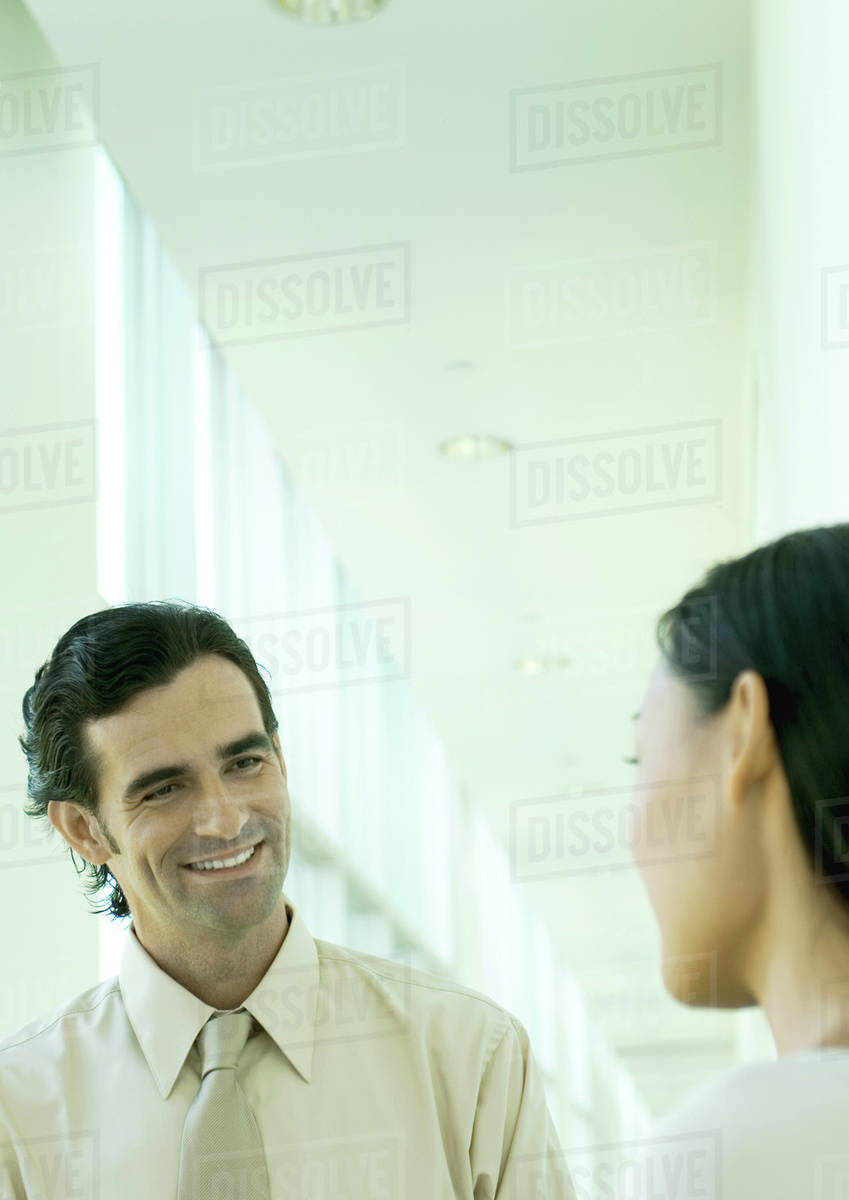 Two colleagues chatting in hallway - Stock Photo - Dissolve