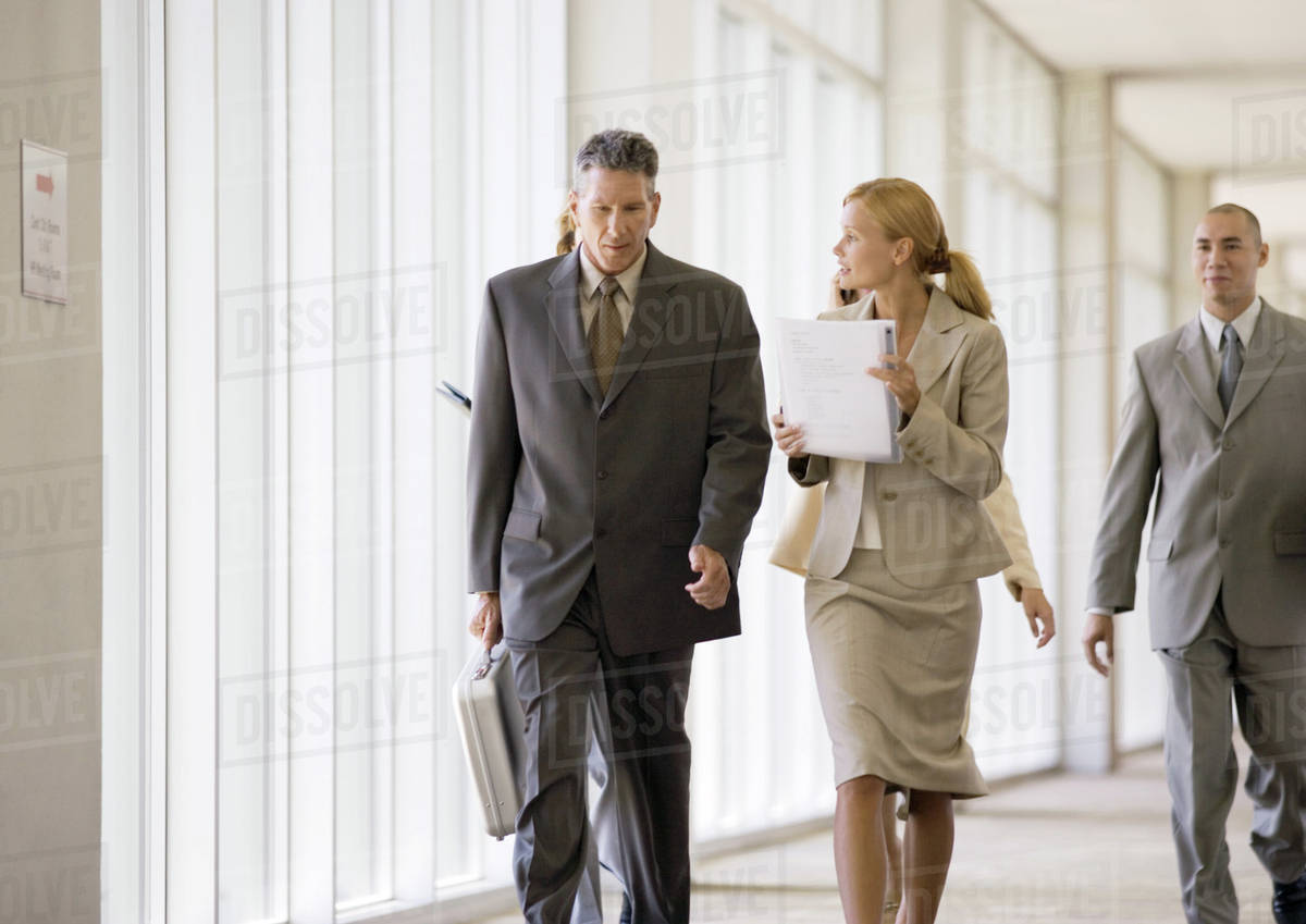 Group of business executives walking through corridor - Royalty-free ...