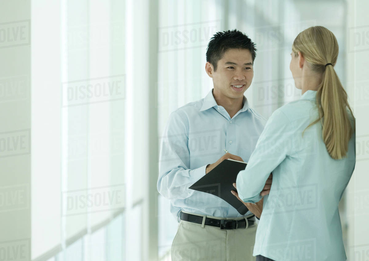 Two office workers talking in corridor - Royalty-free Stock Photo ...