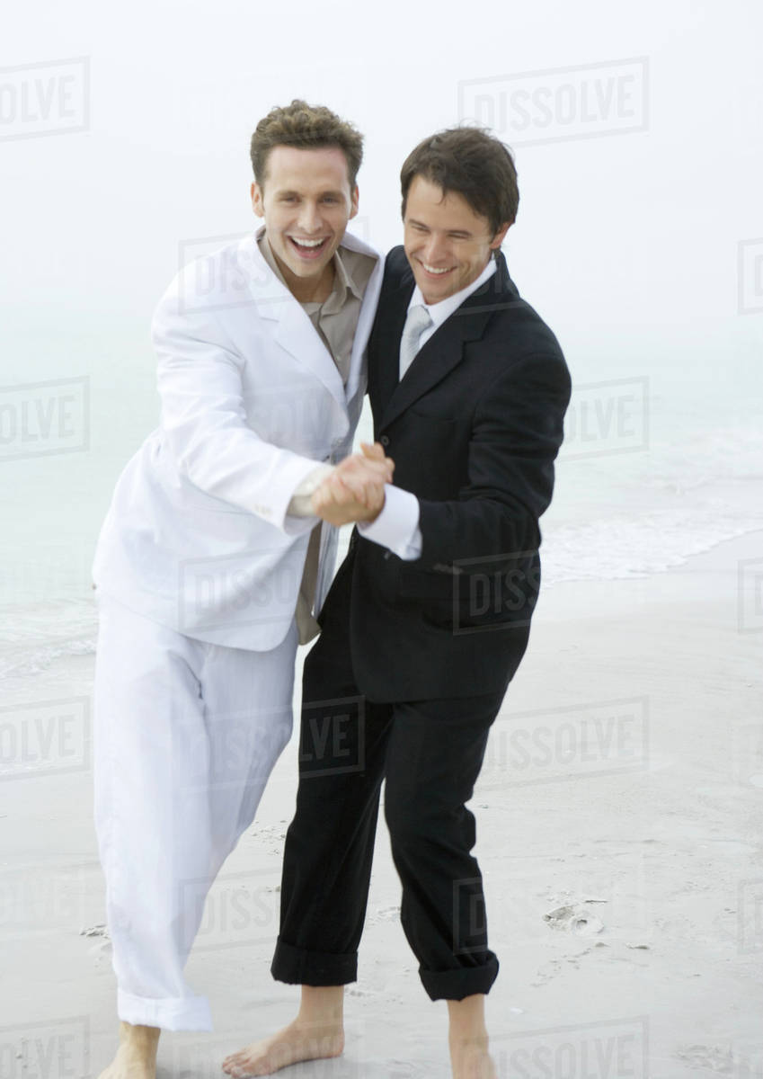 Groom and best man dancing on beach - Royalty-free Stock Photo | Dissolve