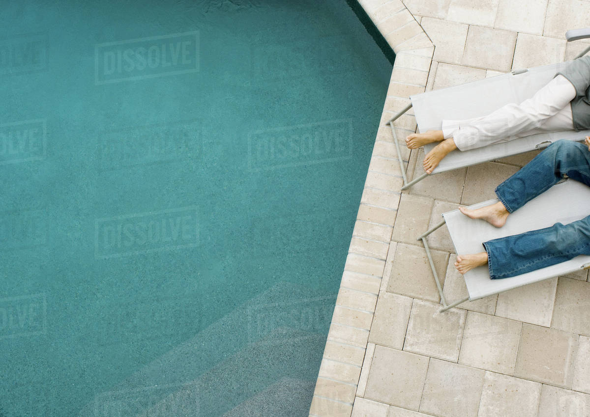 Couple lounging by pool, cropped - Royalty-free Stock Photo | Dissolve
