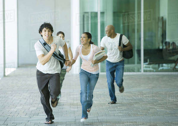 Group of students running on campus - Stock Photo - Dissolve