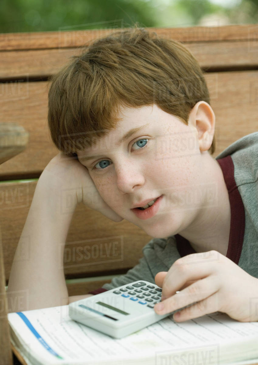 Boy with calculator and school book - Stock Photo - Dissolve