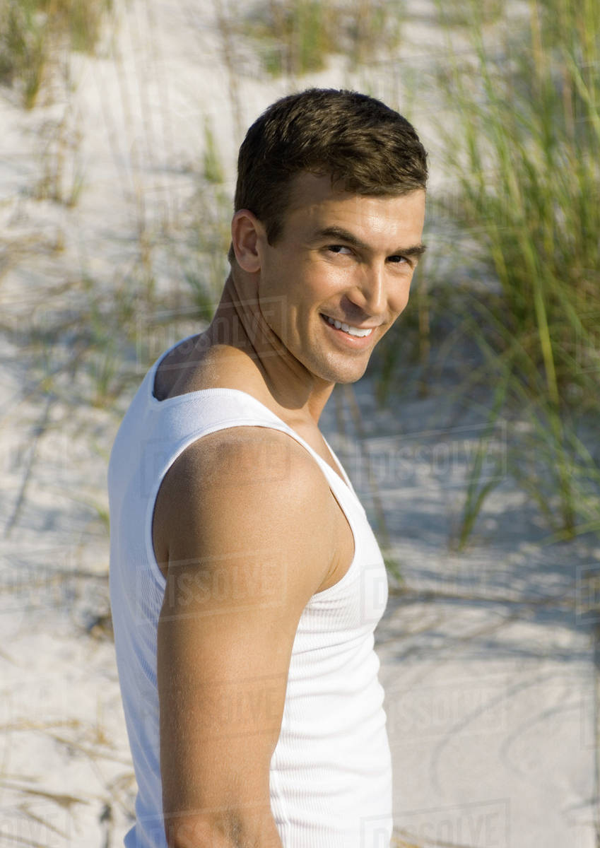 Man on beach, smiling at camera - Stock Photo - Dissolve