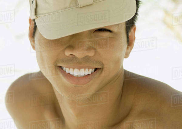 Man wearing cap tilted over eye - Royalty-free Stock Photo | Dissolve