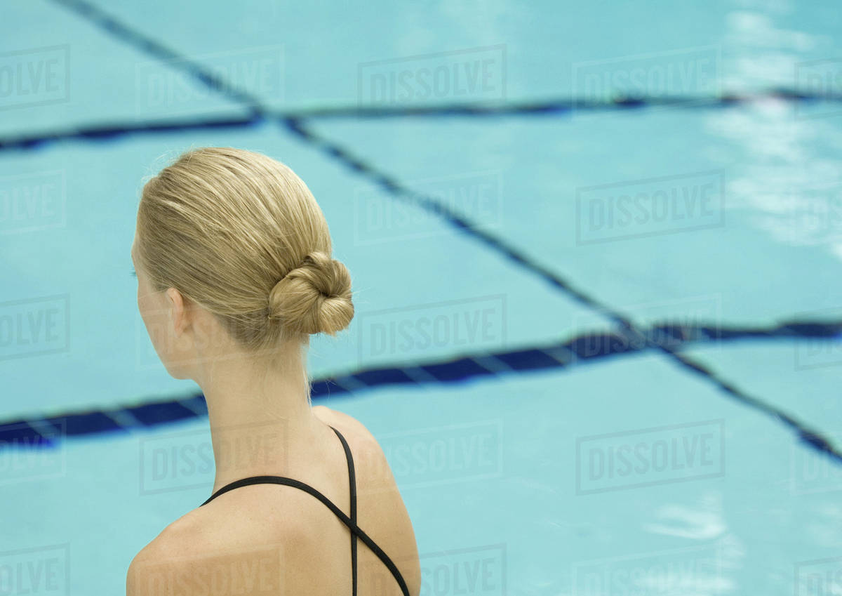 Woman facing pool, rear view - Royalty-free Stock Photo | Dissolve