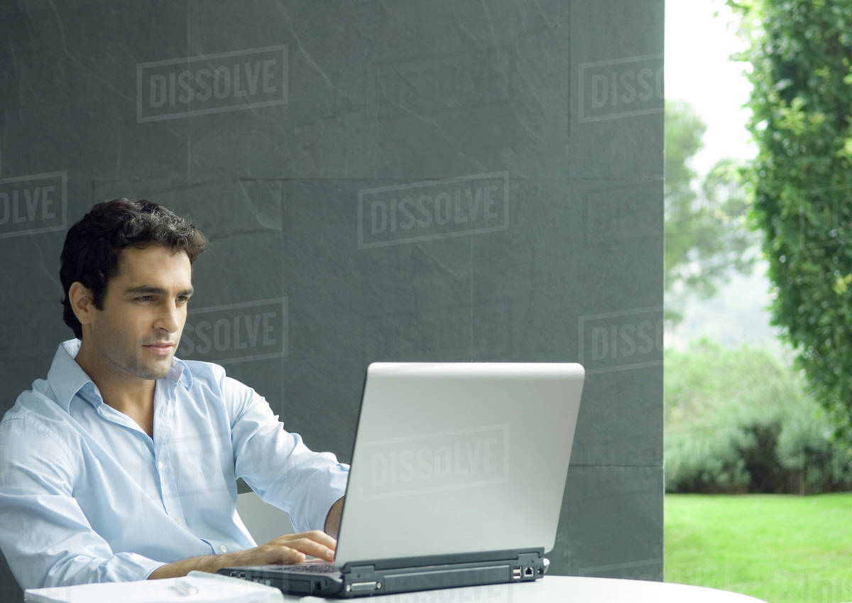 Man using laptop outdoors - Royalty-free Stock Photo | Dissolve