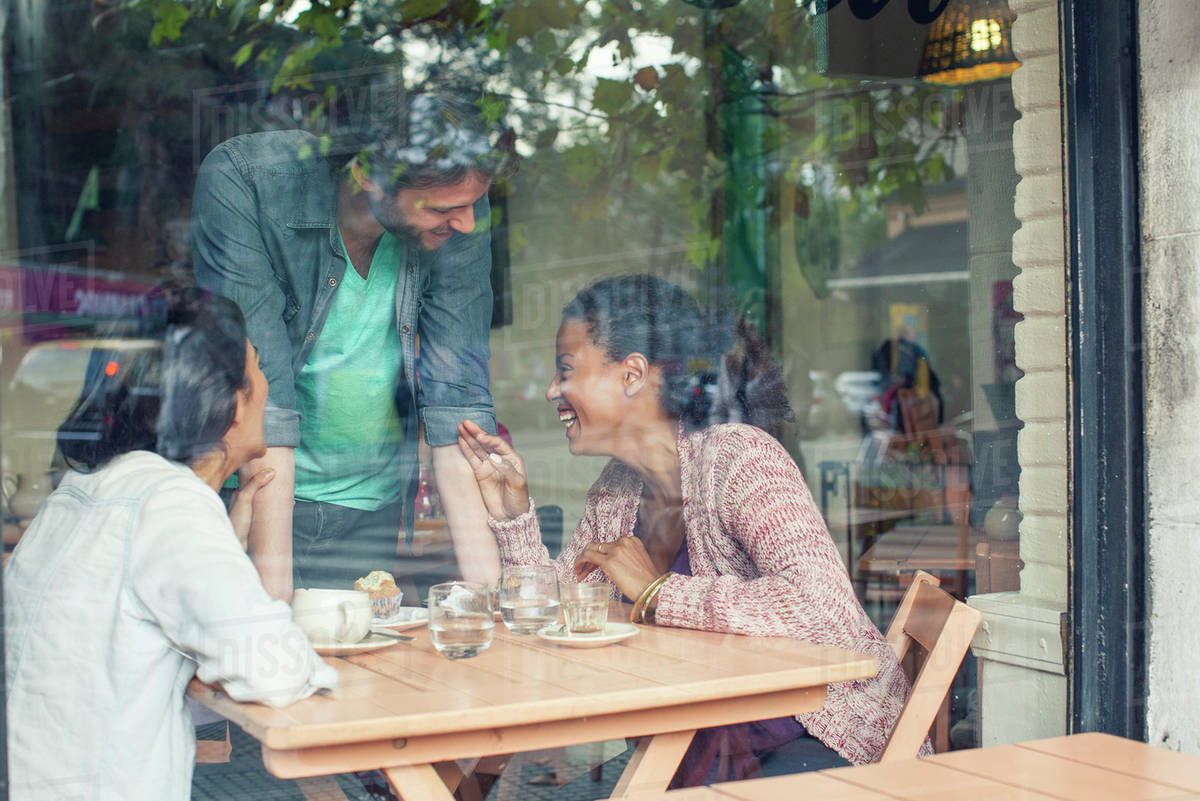 Waiter talking to customers in coffee shop - Royalty-free Stock Photo ...