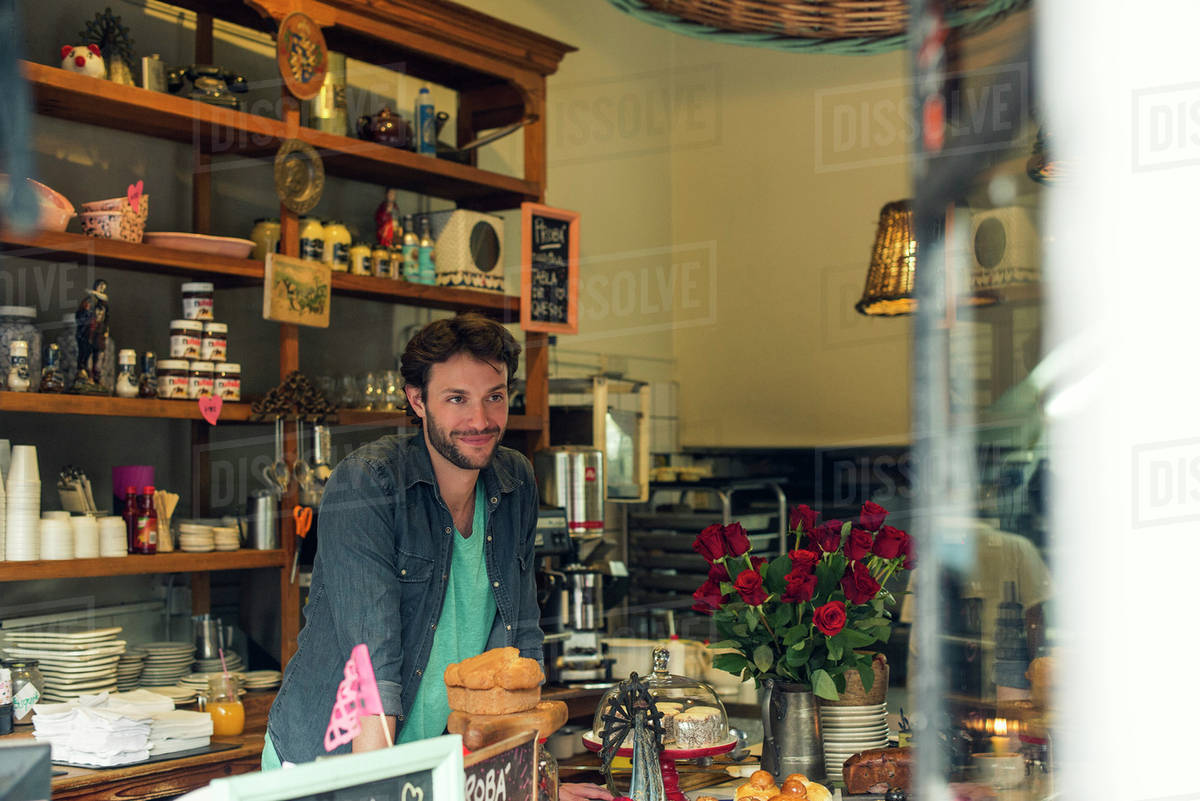 Shopkeeper behind counter at coffee shop - Stock Photo - Dissolve