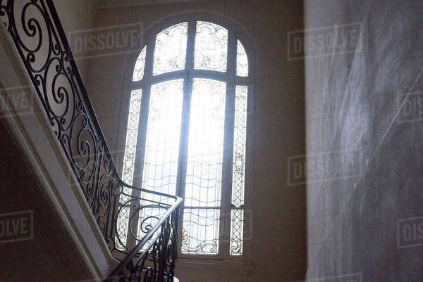 Arched window at top of stairs - Stock Photo - Dissolve