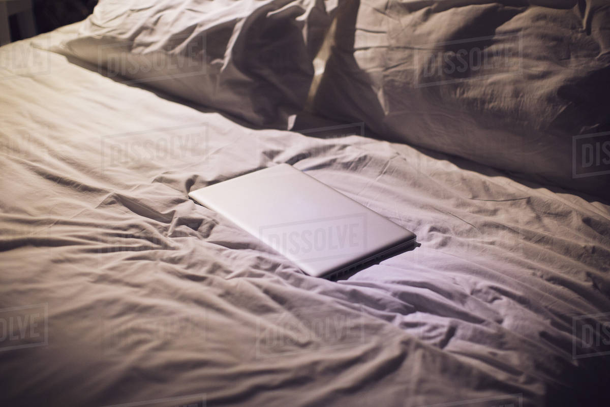 Laptop computer on bed - Royalty-free Stock Photo | Dissolve