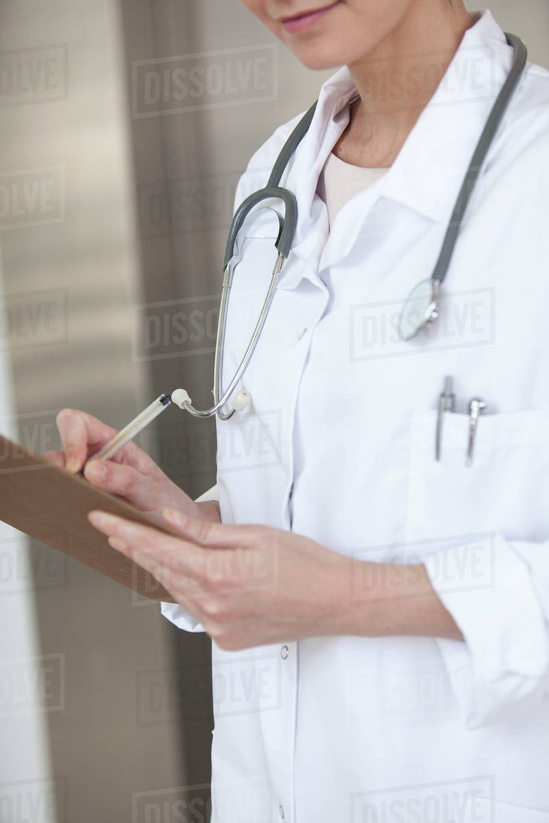 Doctor writing on patient's chart, cropped - Royalty-free Stock Photo ...