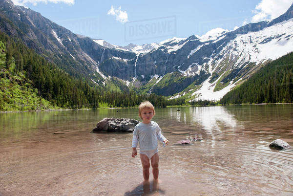 Child wading in water at Glacier National Park, Montana, USA - Royalty ...