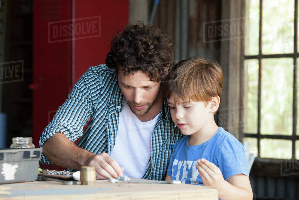 Child helping his father in workshop - Stock Photo - Dissolve