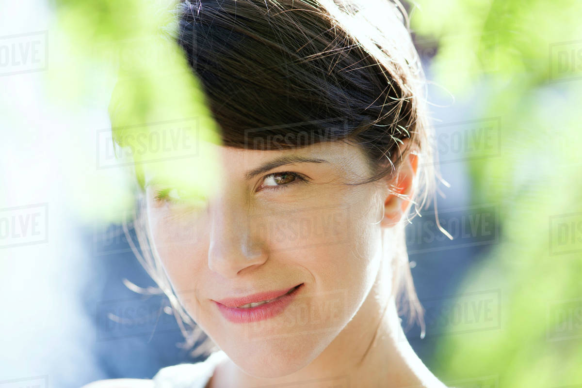 Woman smiling outdoors, portrait - Stock Photo - Dissolve
