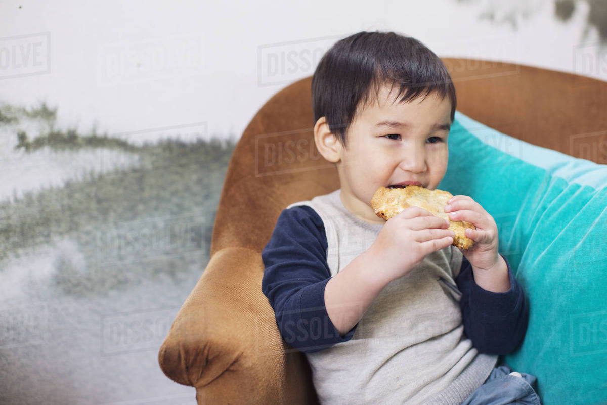 Little boy eating cookie - Royalty-free Stock Photo | Dissolve