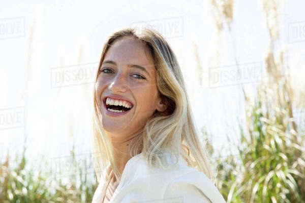 Woman laughing outdoors, portrait - Royalty-free Stock Photo | Dissolve