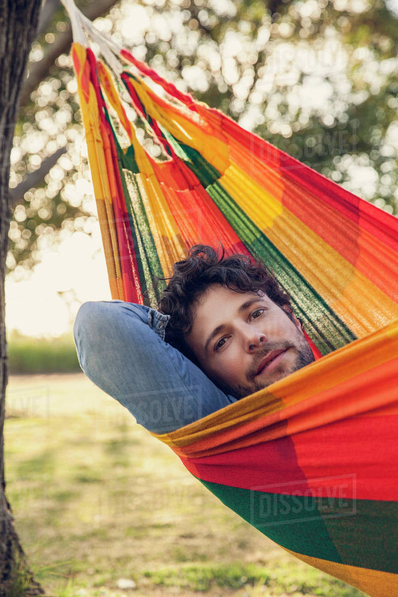 Man relaxing in hammock, portrait - Royalty-free Stock Photo | Dissolve