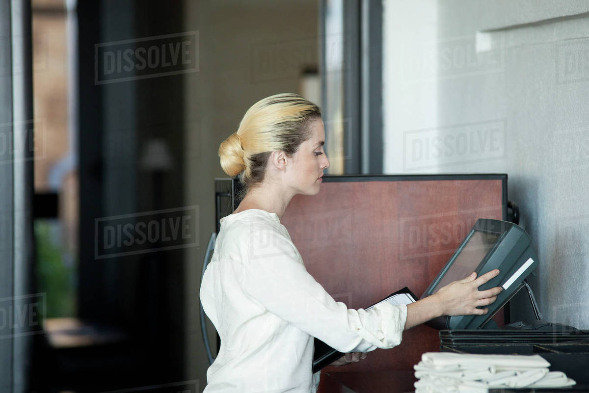 Waitress using computer in restaurant - Stock Photo - Dissolve