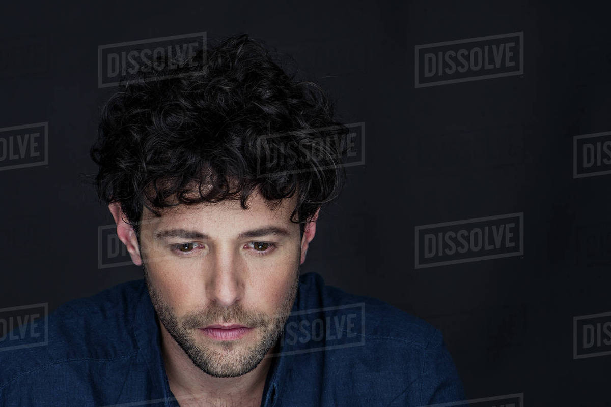 Man looking down in thought, portrait - Royalty-free Stock Photo | Dissolve