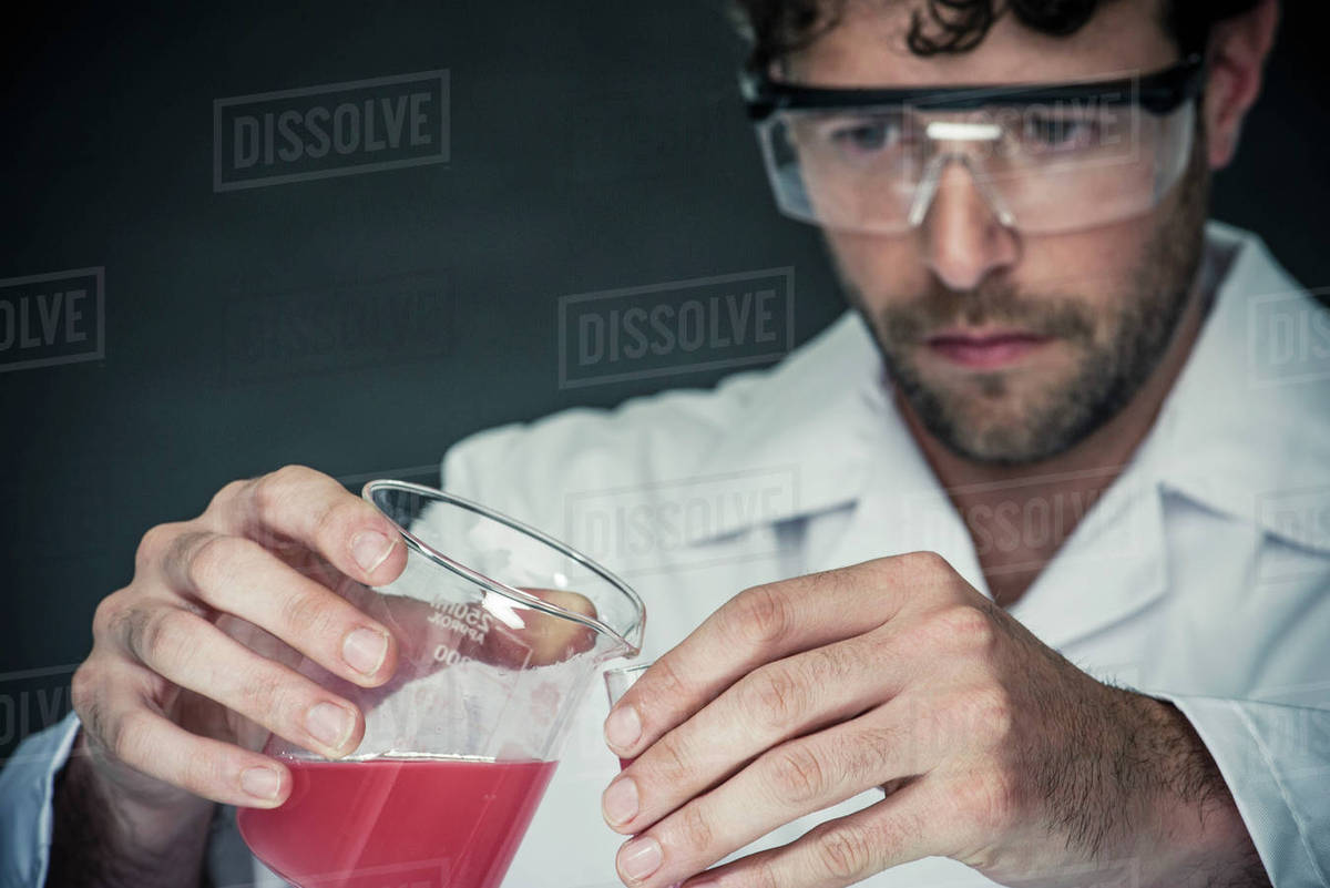 Scientist pouring liquid into test tube in lab - Royalty-free Stock ...