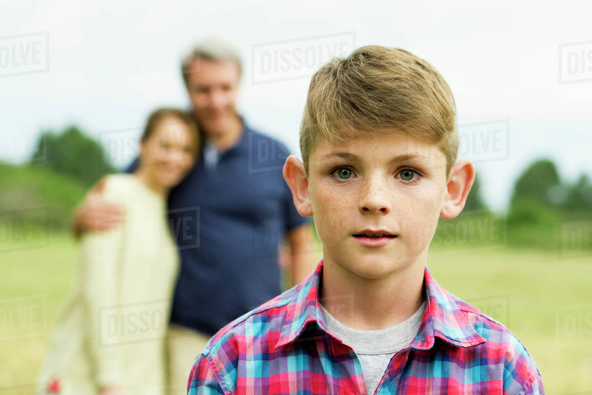 Boy with parents in background, portrait - Stock Photo - Dissolve