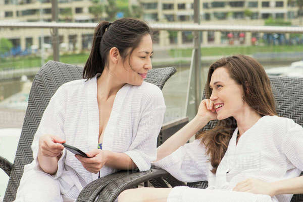 Women in robes reclining and chatting outdoors - Royalty-free Stock ...