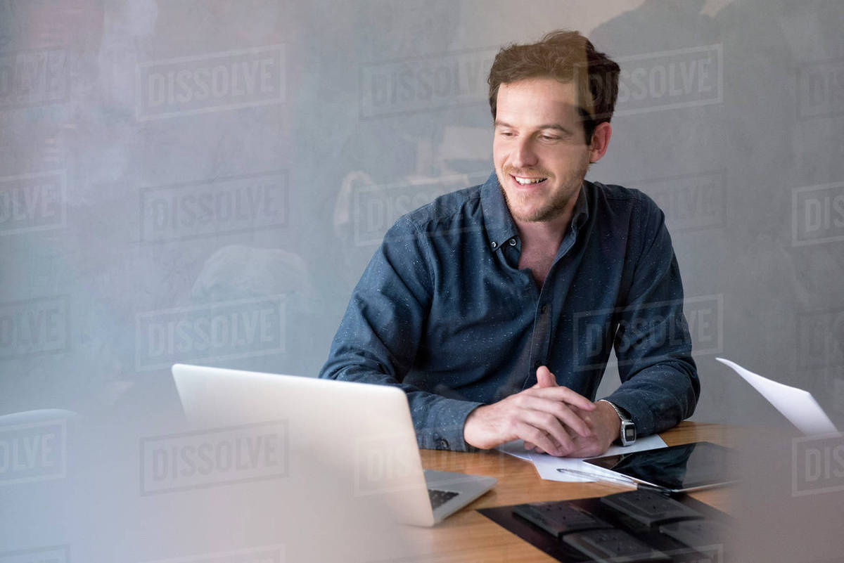 Man in office using laptop computer - Royalty-free Stock Photo | Dissolve
