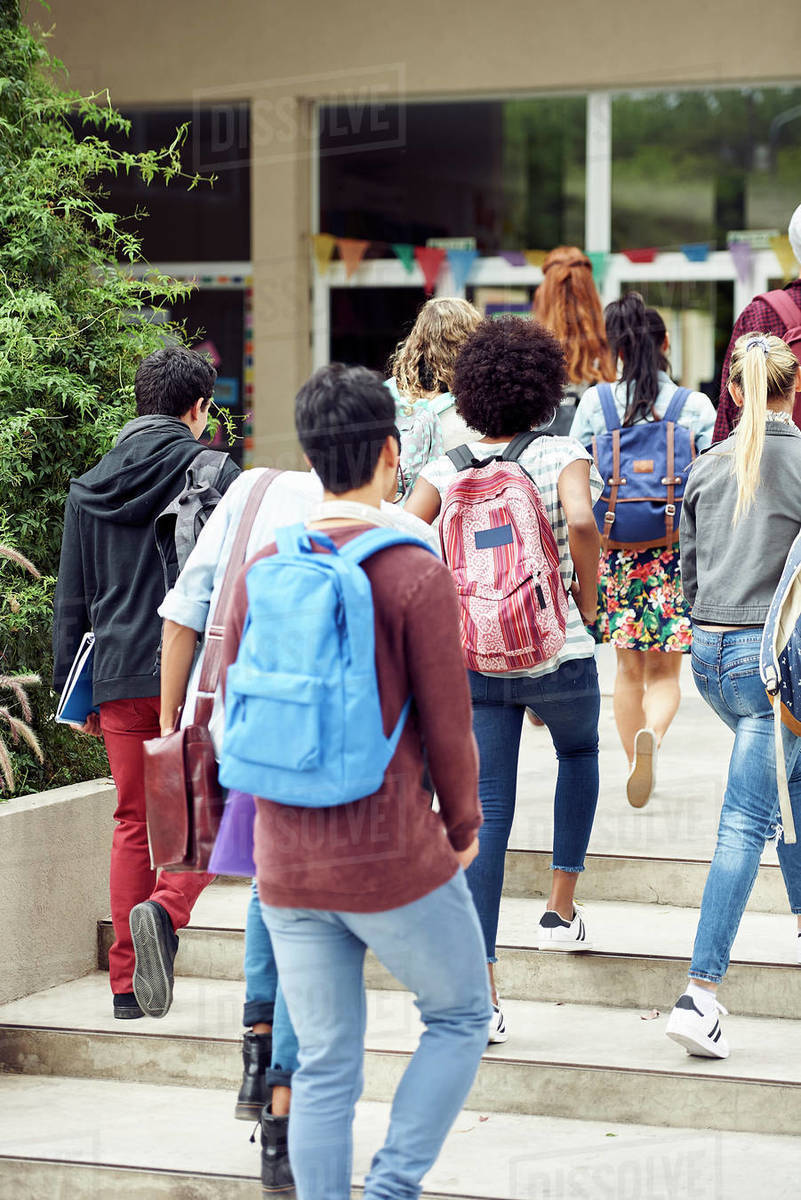 College students walking toward campus building, rear view - Royalty ...
