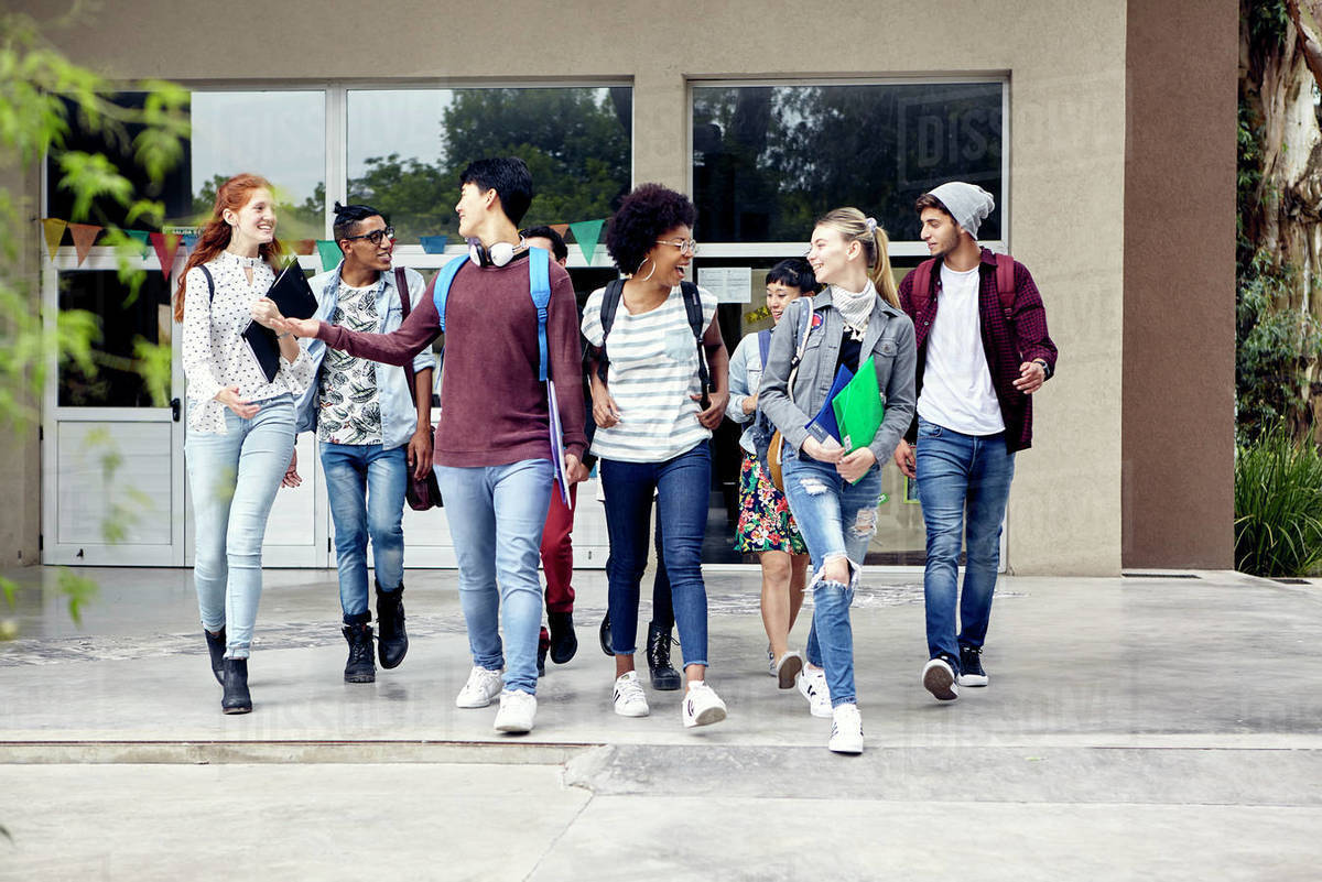 Classmates walking and chatting together on college campus - Royalty ...