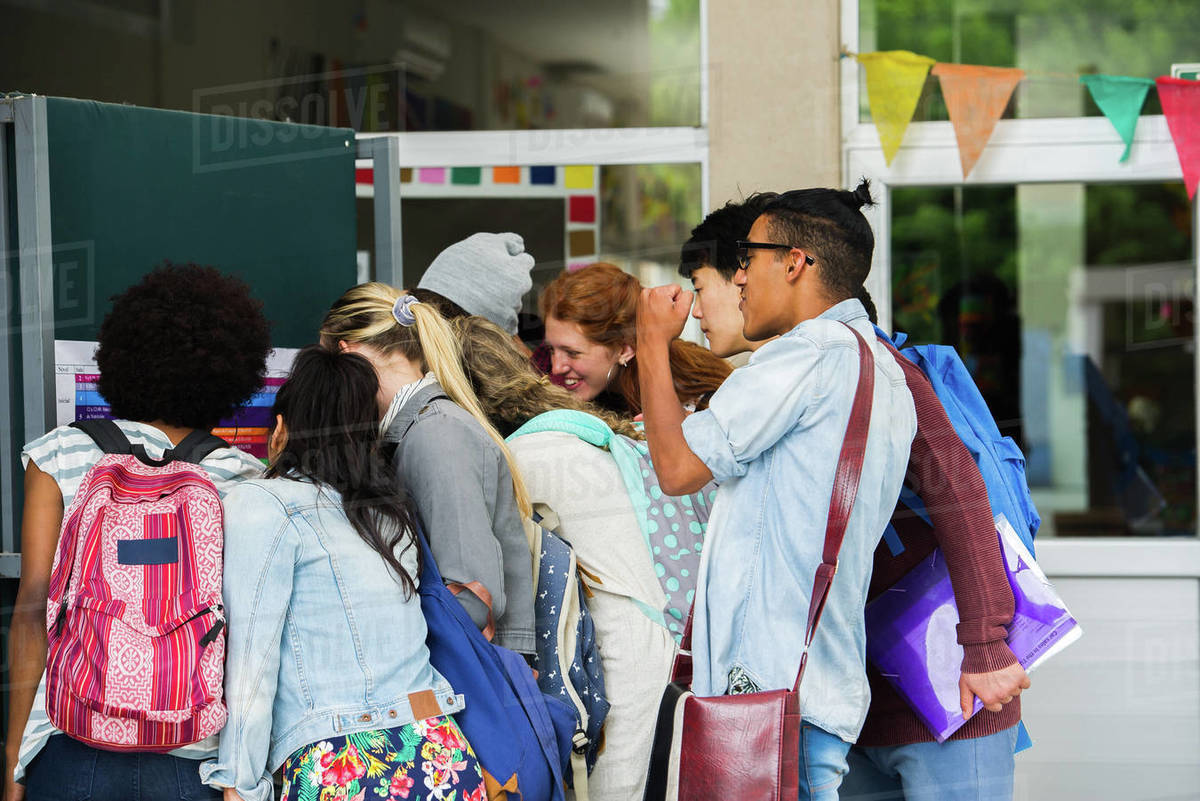 College students checking grades on bulletin board - Stock Photo - Dissolve