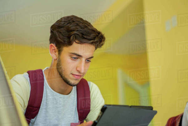 College student looking at digital tablet between classes - Royalty ...