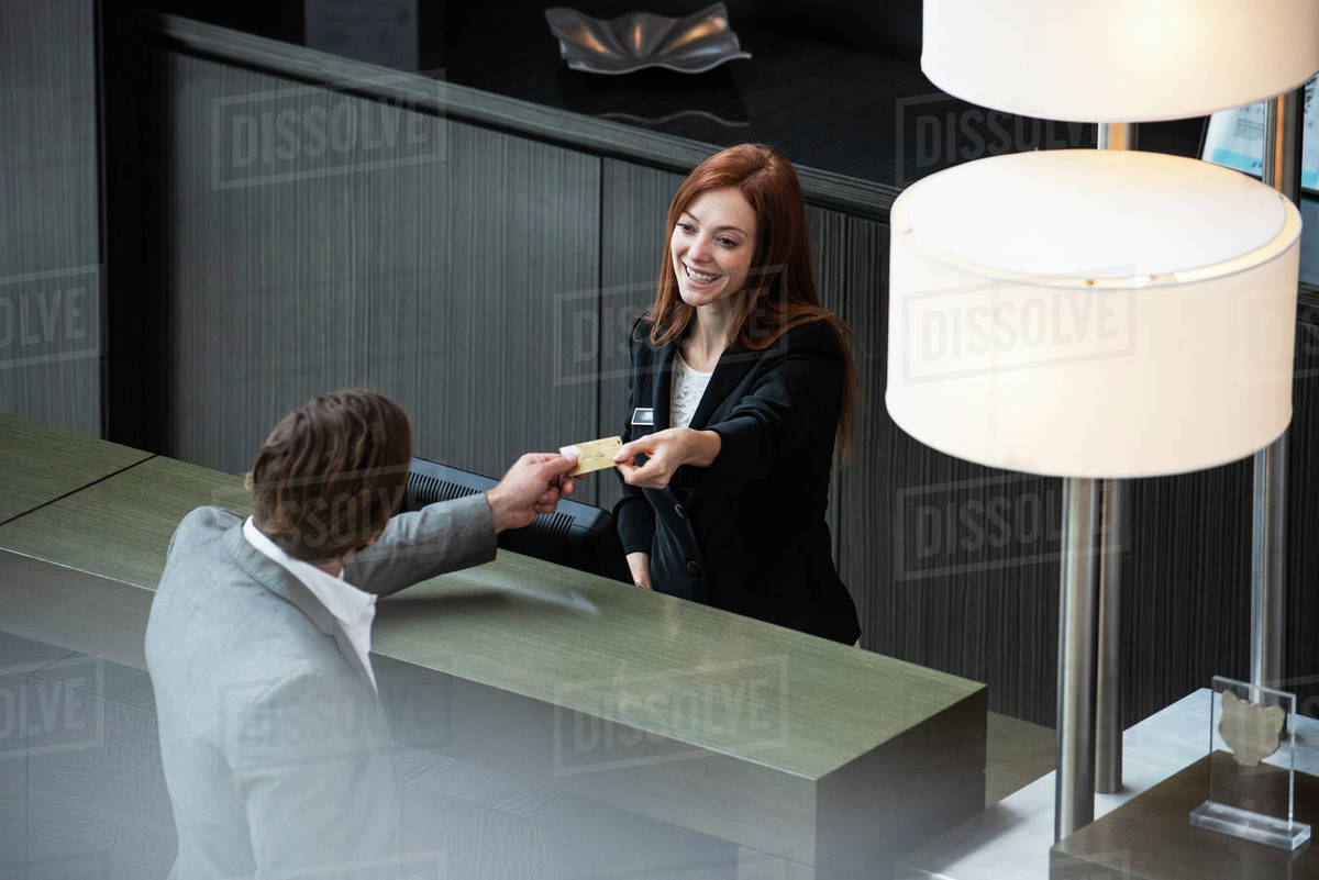 Female receptionist giving credit card to businessman - Stock Photo ...