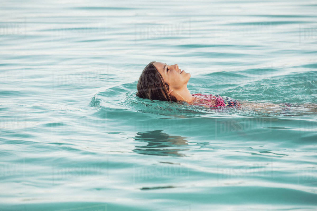 Smiling girl swimming in pool - Royalty-free Stock Photo | Dissolve