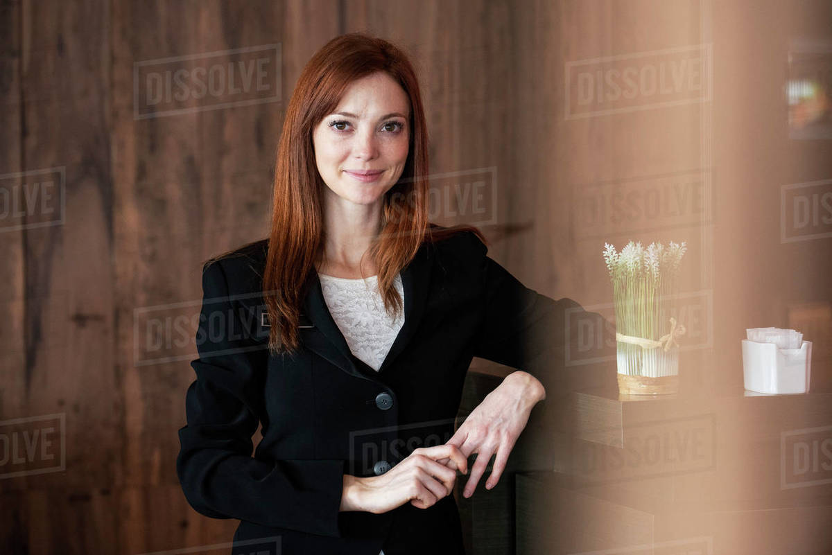 Female receptionist standing in hotel - Royalty-free Stock Photo | Dissolve