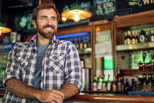Man leaning against bar counter - Royalty-free Stock Photo | Dissolve