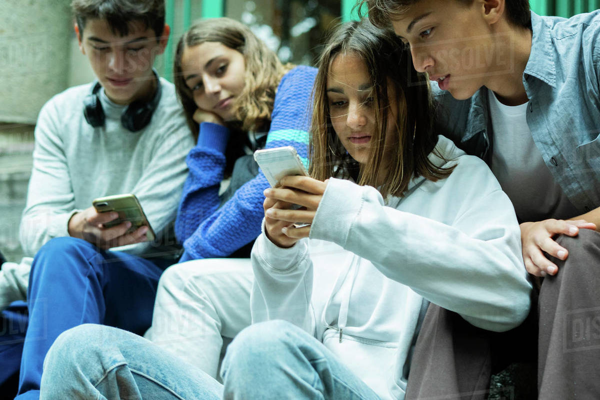 Friends using smartphones - Royalty-free Stock Photo | Dissolve