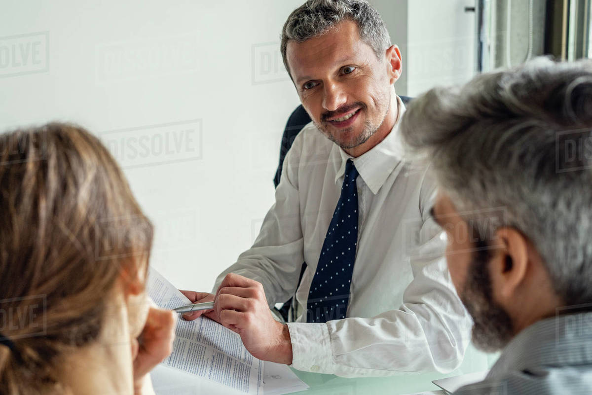 Real estate agent discussing document with couple - Royalty-free Stock ...