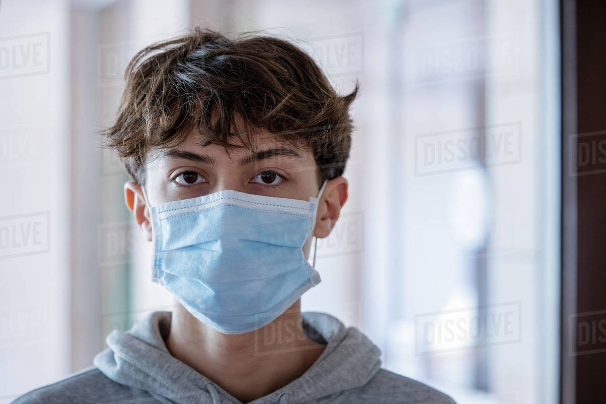 Close up of teenage boy wearing blue surgical mask - Royalty-free Stock ...