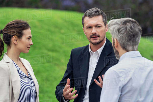Businesspeople talking in public park - Royalty-free Stock Photo | Dissolve