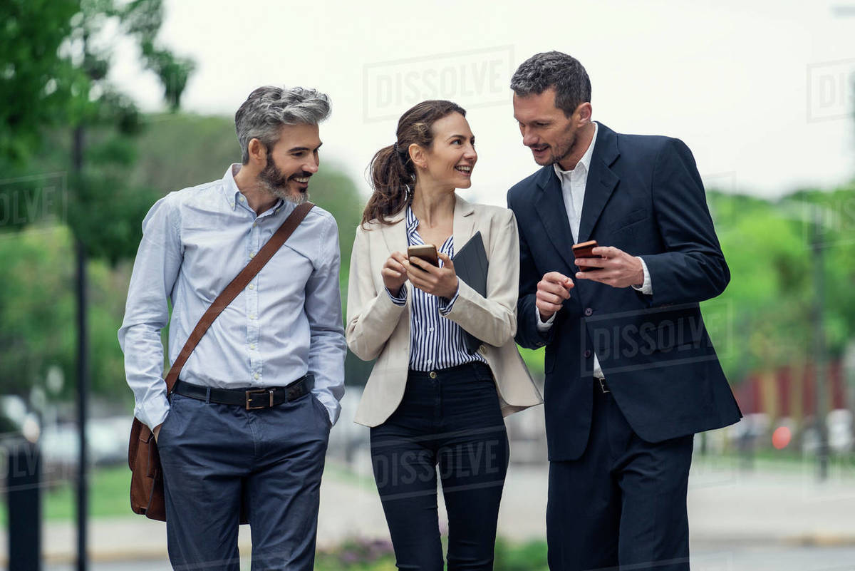 Business people using smartphones in public park - Royalty-free Stock ...