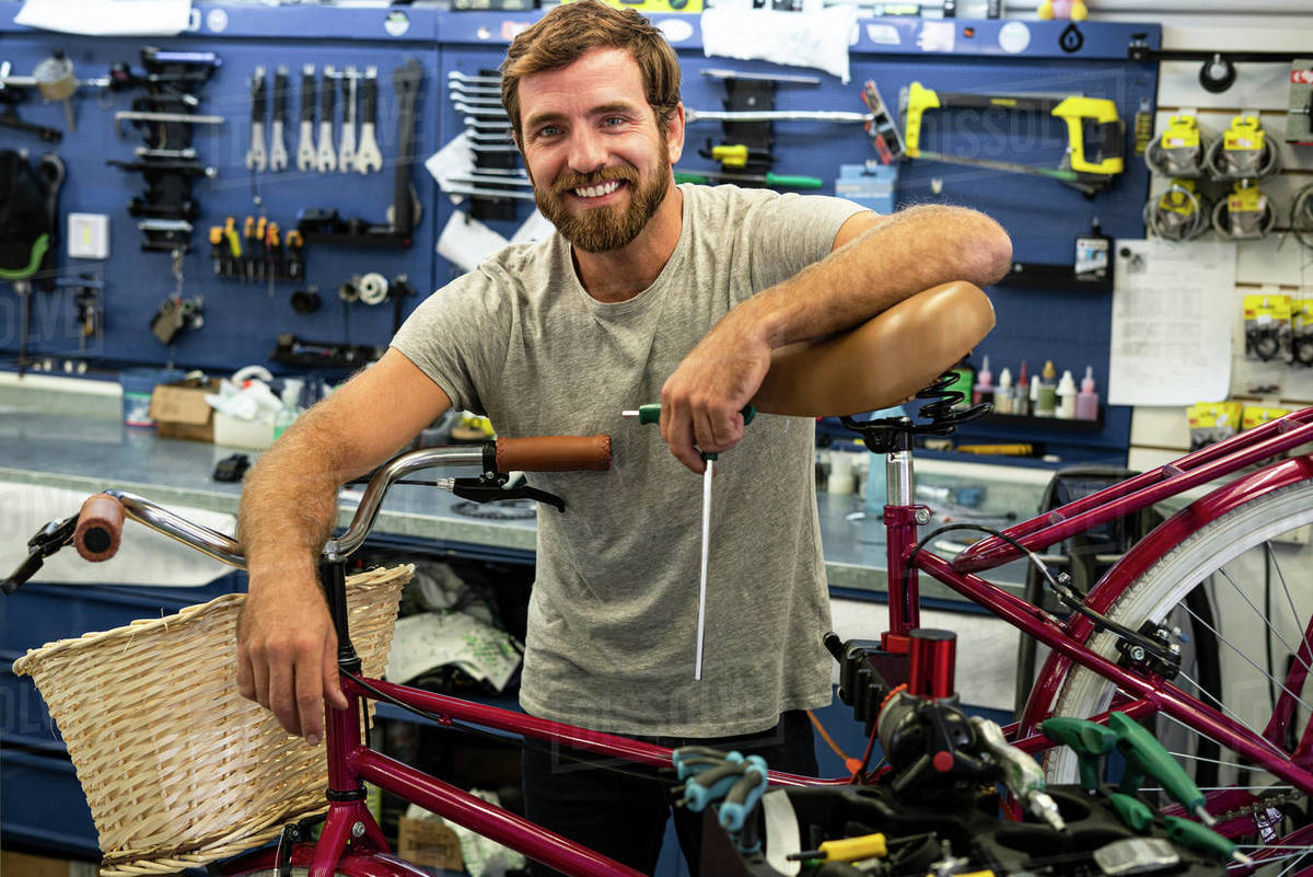 Mechanic leaning on bicycle - Stock Photo - Dissolve