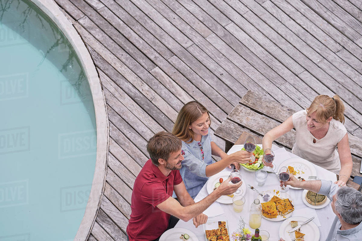 Family having lunch at poolside - Royalty-free Stock Photo | Dissolve
