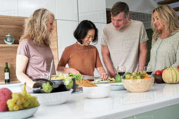 Group of senior friends watching how to cook a meal while gathered ...